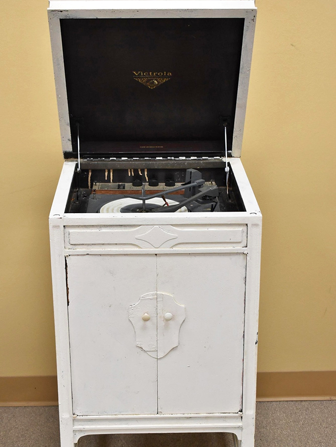 A vintage Victrola record player stands as a white-painted time capsule, ready to bring music history into someone's home.