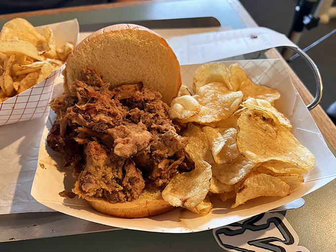 Pulled pork piled high on a soft bun with kettle chips&mdash;proof that sometimes the simplest pleasures deliver the most profound satisfaction.