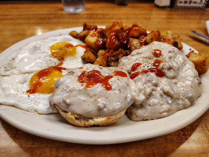 Biscuits swimming in creamy sausage gravy with sunny-side-up eggs &ndash; breakfast architecture that would make Frank Lloyd Wright proud.