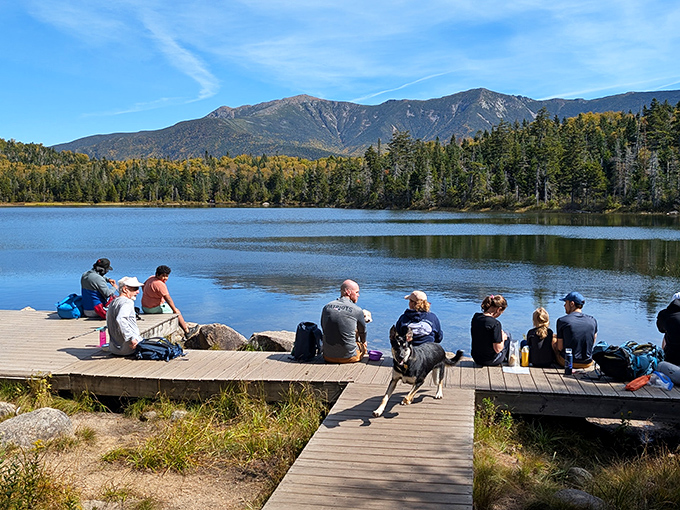 Lakeside philosophers pondering life's big questions: "How is this view real?" and "Why didn't I bring more snacks?"
