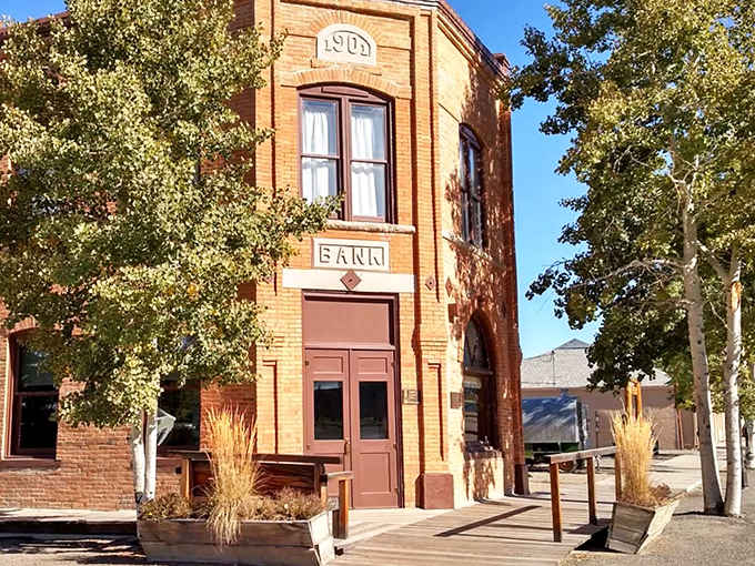 Historic 1909 bank building stands proudly in Wyoming sunshine, now repurposed while preserving its architectural charm.