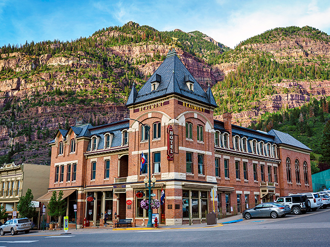 Red brick elegance rises against dramatic cliffs, creating a scene worthy of any European postcard.