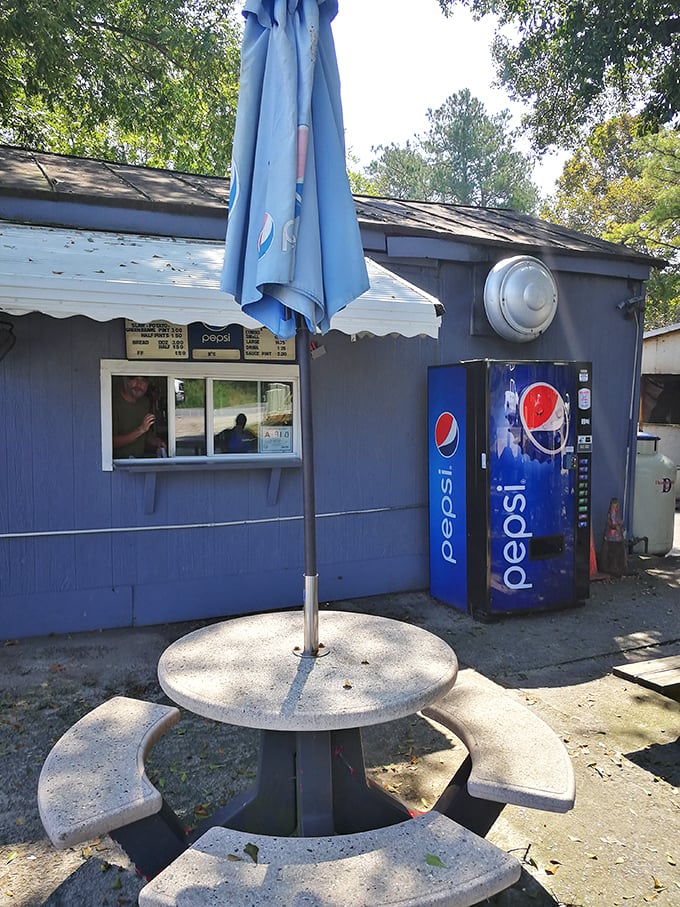 The blue exterior and simple picnic table say "no fuss," but the line of cars tells the real story&mdash;B's Barbecue is worth the pilgrimage.