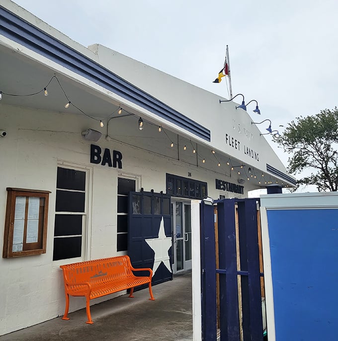 The bright orange bench adds a pop of color to Fleet Landing's maritime-inspired entrance, where harbor views enhance every meal.