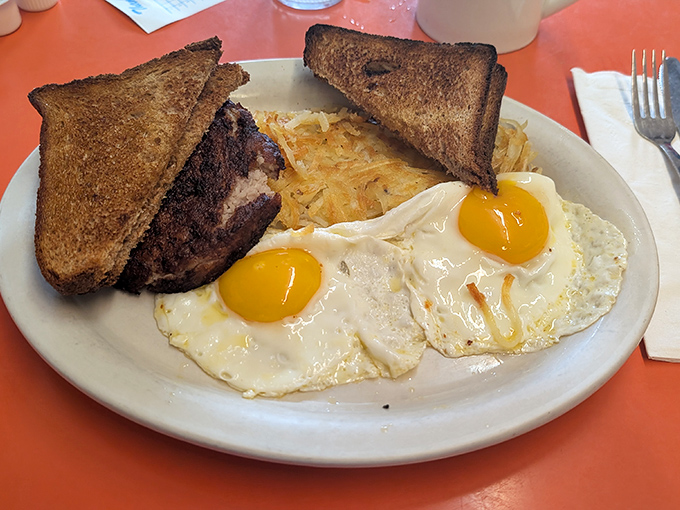 Sunny-side up eggs with hash browns and toast&mdash;the breakfast equivalent of a perfectly executed symphony where every element plays its part.
