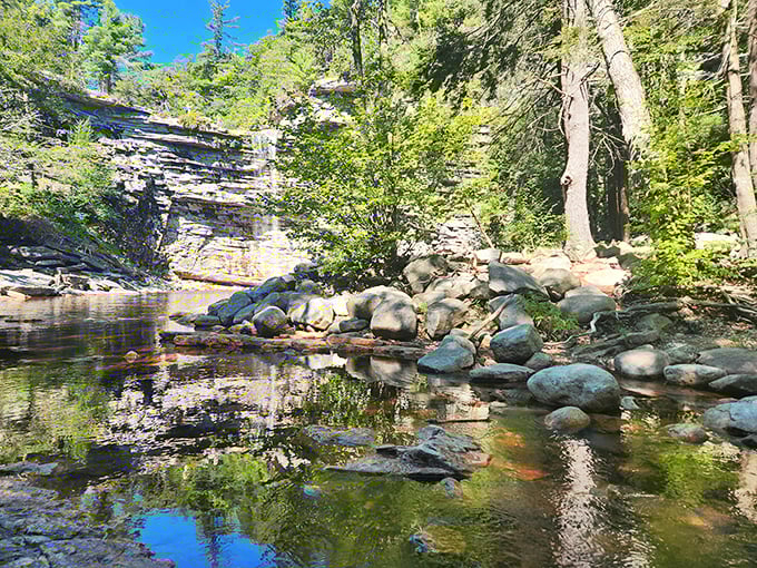 Mother Nature's version of a spa day. The peaceful pool beneath these layered rock formations offers natural tranquility no day pass could buy.