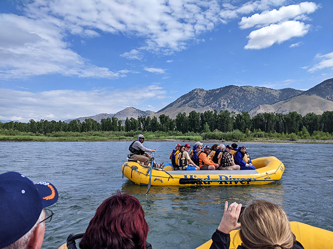 Yellow rafts navigate the river's currents, carrying adventurers through scenery that makes every splash feel like pure freedom.