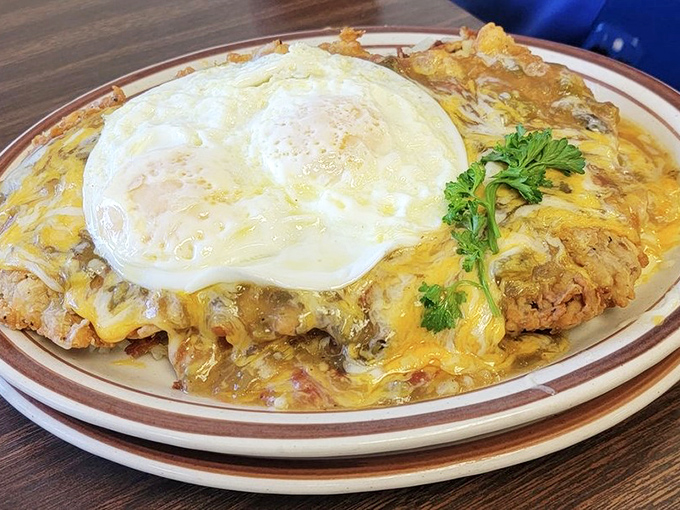 Breakfast nirvana achieved: melted cheese cascading over crispy potatoes, topped with perfectly cooked eggs. The morning struggle just became worth it.