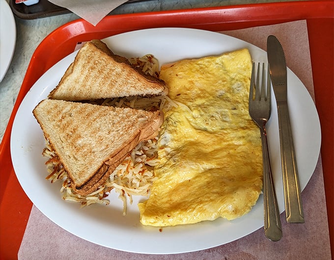 That omelet is fluffier than a cloud convention, served with hash browns and toast for breakfast champions.