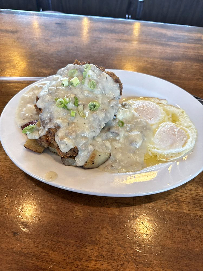 Comfort food elevated to an art form&mdash;sausage gravy cascading over potatoes like a savory waterfall, with sunny-side eggs standing by for the perfect bite.