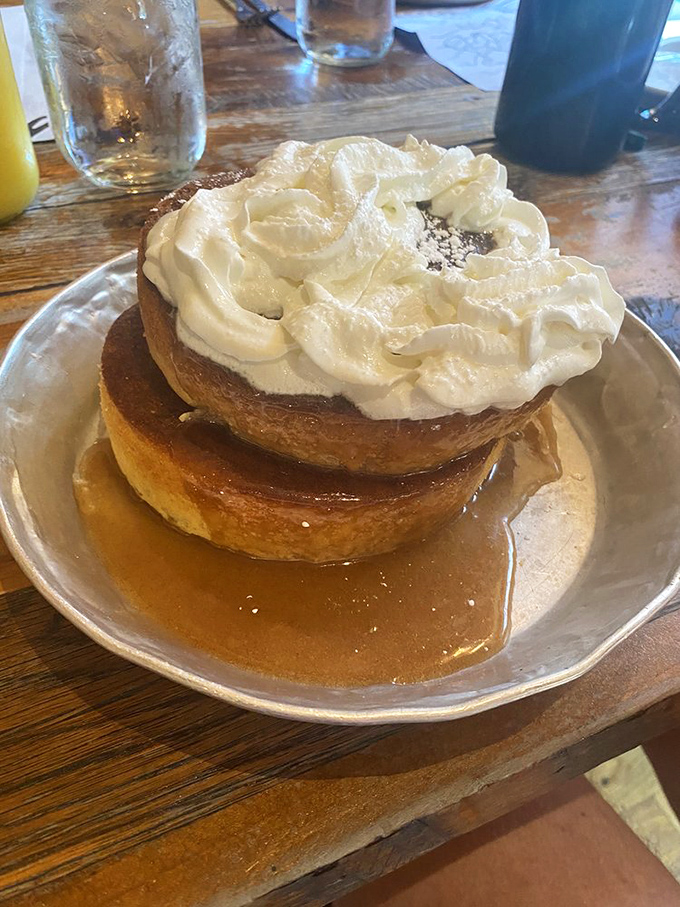 These pancakes aren't just stacked&mdash;they're elevated to an art form, crowned with a cloud of whipped cream and swimming in maple syrup.