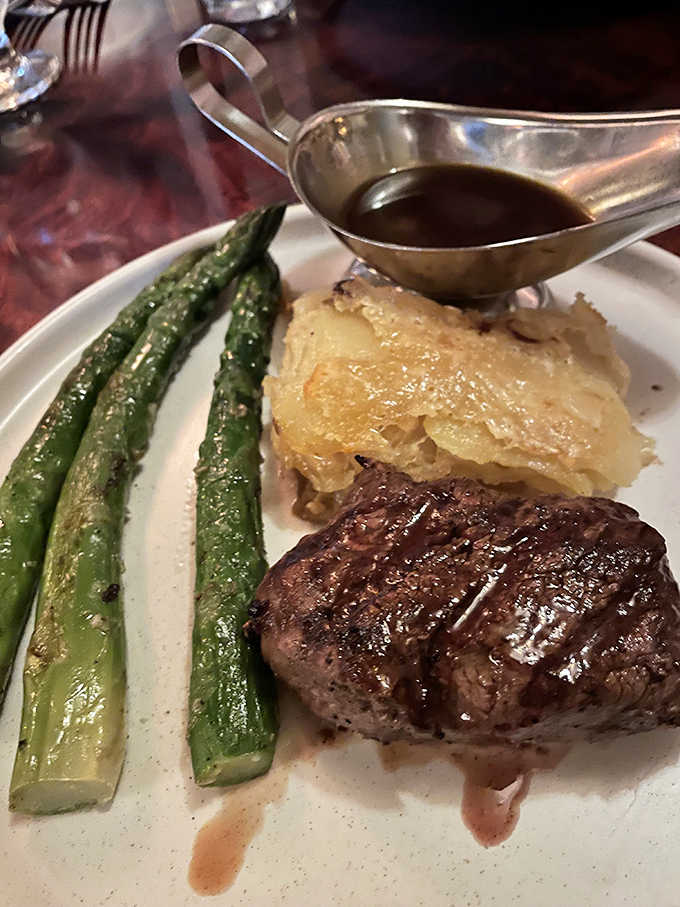 This isn't just any steak&mdash;it's a masterclass in temperature control, with asparagus standing at attention alongside potato gratin that would make a Frenchman weep.