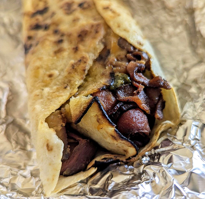 This isn't just meat in a tortilla—it's chicharrones with green chile, a New Mexican breakfast tradition that makes pancakes seem like a sad compromise.