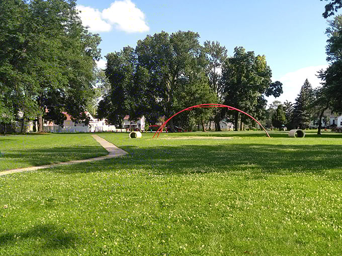 Jackson Park's iconic red arch stands as a whimsical gateway to affordable family fun—no admission required, just bring your imagination.