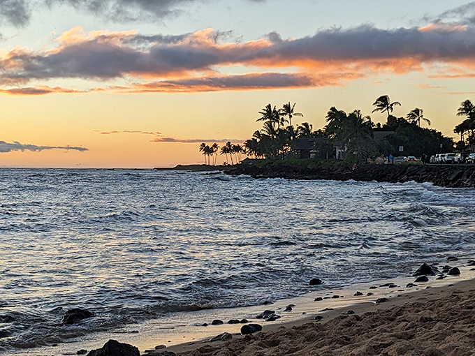 Sunset paints the Pacific in watercolor hues at Koloa's coastline, where the rhythmic percussion of waves provides nature's perfect dinner soundtrack.