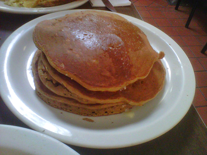 These golden-brown pancakes aren't just breakfast—they're edible sunshine stacked three high, waiting for maple syrup's sweet embrace.