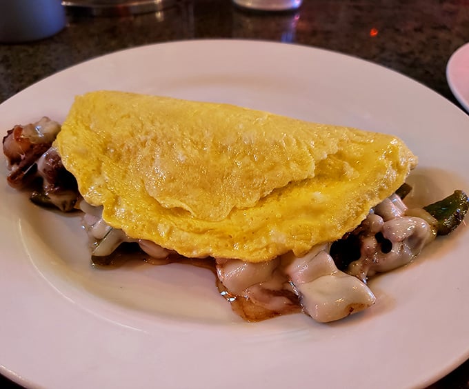 This omelet arrives stuffed with mushrooms and possibilities, folded like a golden envelope of deliciousness.