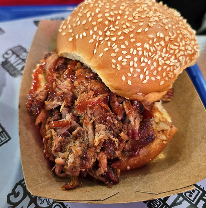 Pulled pork that doesn't just fall apart&mdash;it surrenders completely. Nestled in a sesame bun, it's Iowa comfort food elevated to art form.