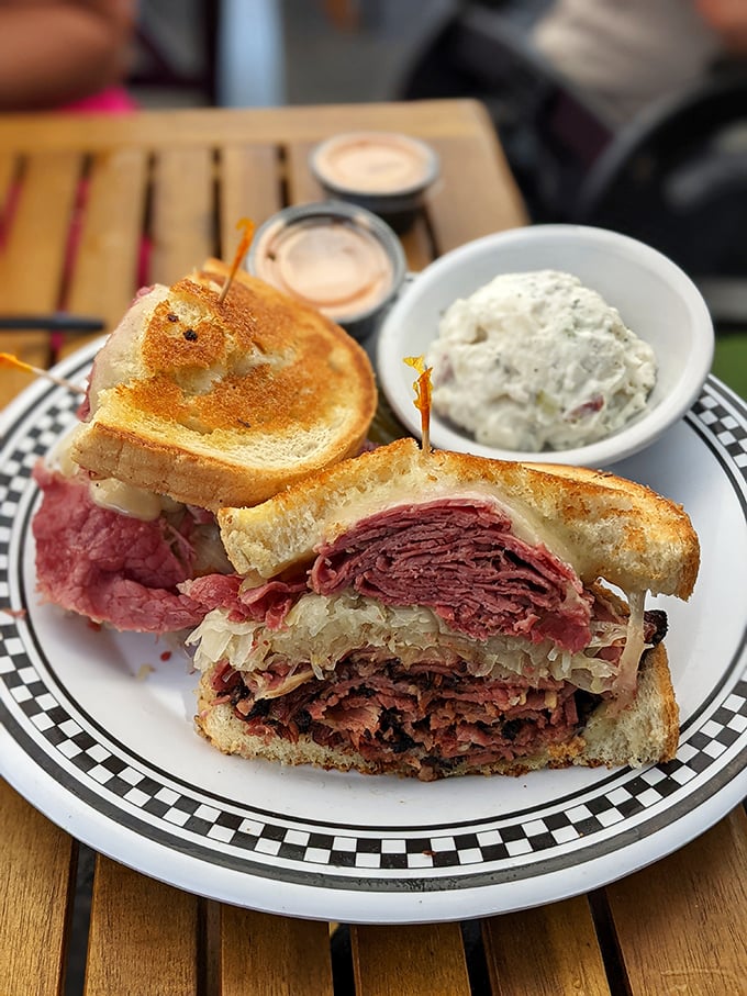 The Reuben arrives like a work of art, layers of corned beef and sauerkraut creating sandwich perfection.