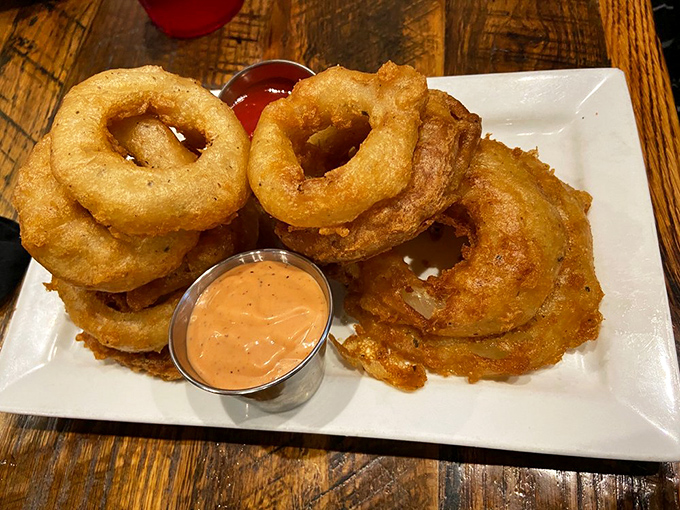 These aren't just onion rings; they're golden halos of crispy perfection with dipping sauces that deserve their own fan club.