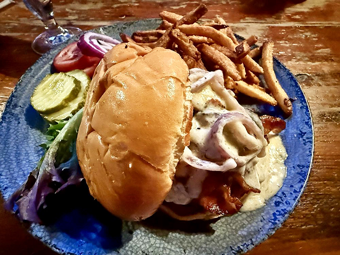 A sandwich that demands both hands and your full attention – this burger's toppings spill out like secrets that can't be contained.