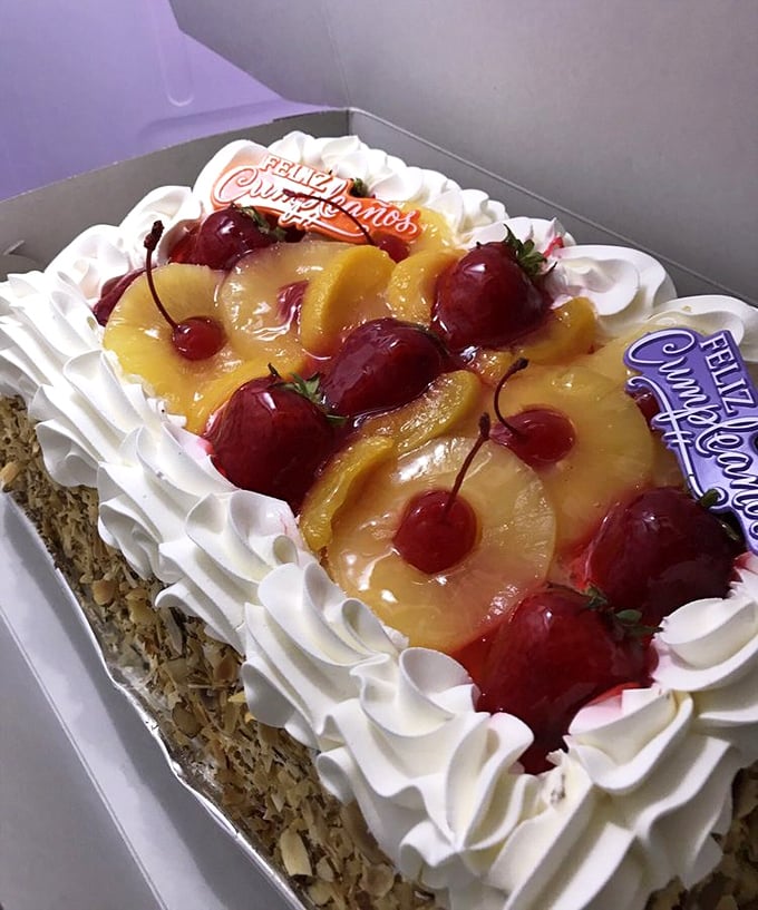 This tres leches cake topped with fruit and cherries is basically edible art with a "Feliz Cumplea&ntilde;os" bonus.