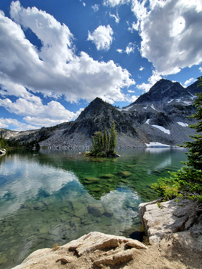 Mirror-like alpine waters reflect snow-capped peaks at this pristine mountain lake&mdash;nature showing off with the subtlety of a Broadway musical finale.