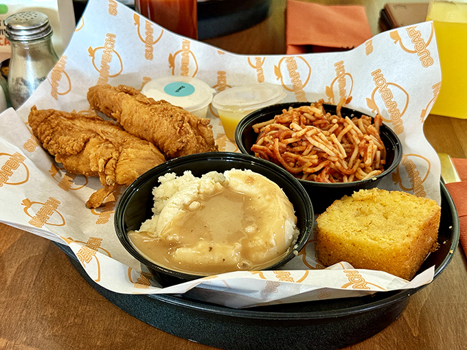 A complete soul food symphony on one plate &ndash; crispy chicken strips, creamy mashed potatoes, saucy spaghetti, and cornbread that doesn't know it's in Iowa.