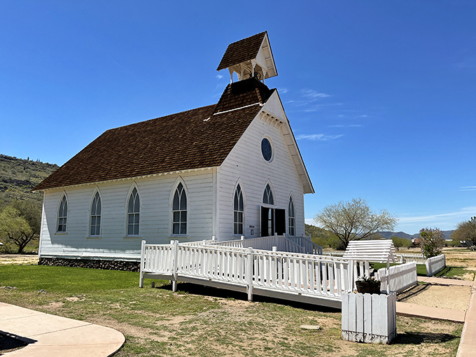 The pristine white church gleams against the desert backdrop like a wedding cake in a sandstorm. Sunday services with a side of sunburn.