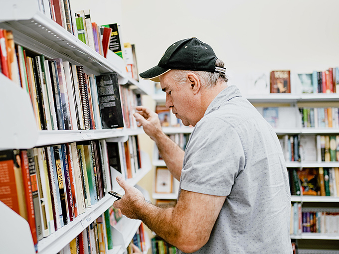 In the stacks of literary possibility, this gentleman isn't just finding books&mdash;he's discovering stories, knowledge, and the satisfaction of paying paperback prices for hardcover wisdom.