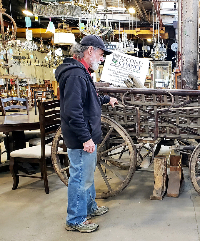 Treasure hunters come in all forms. This shopper contemplates an antique wagon wheel, perhaps envisioning it as tomorrow's conversation-starting coffee table.