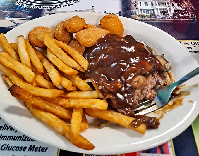 This hamburger steak swimming in rich brown gravy isn't just a meal&mdash;it's therapy on a plate, complete with crispy fries and tater tots.
