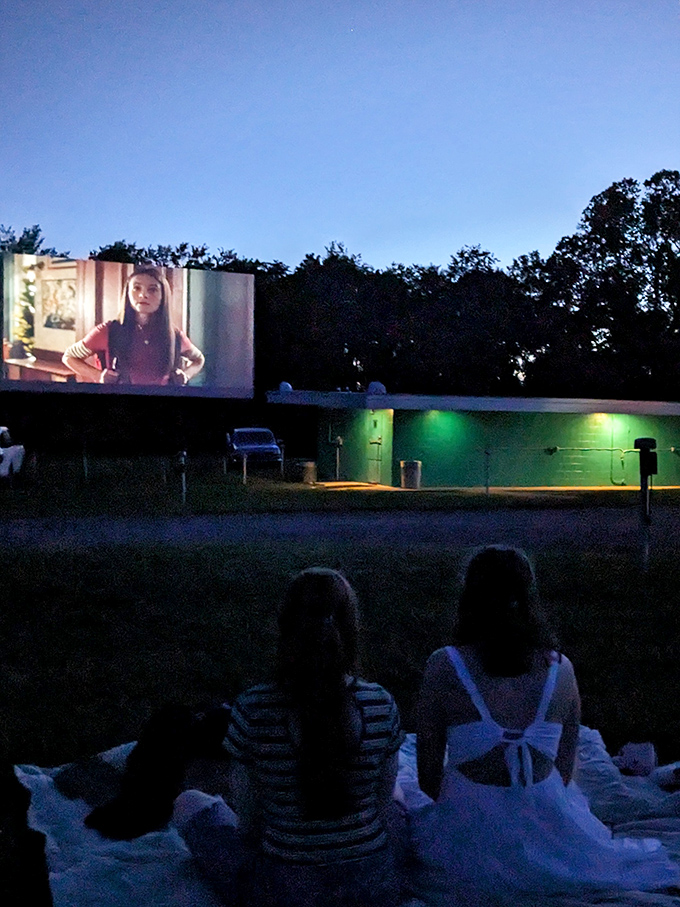 As darkness falls, the magic begins. Families settle in with blankets while the screen illuminates faces with that unmistakable movie glow.
