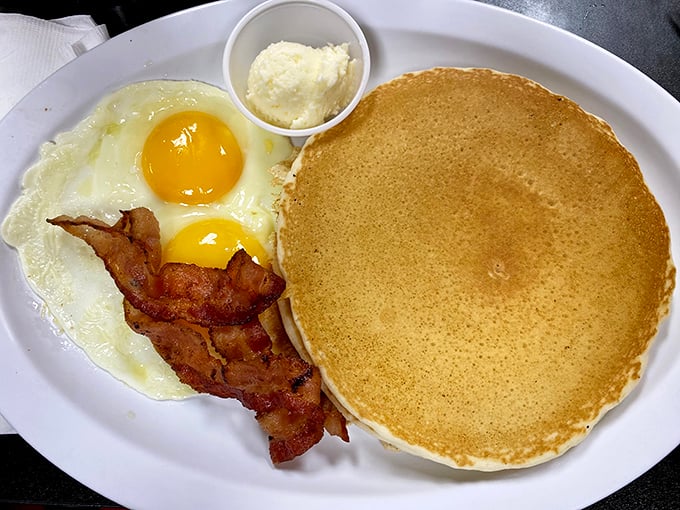 The pancake trinity: golden-brown disc, perfectly cooked eggs, and bacon that's found that magical space between chewy and crisp. Breakfast nirvana achieved.