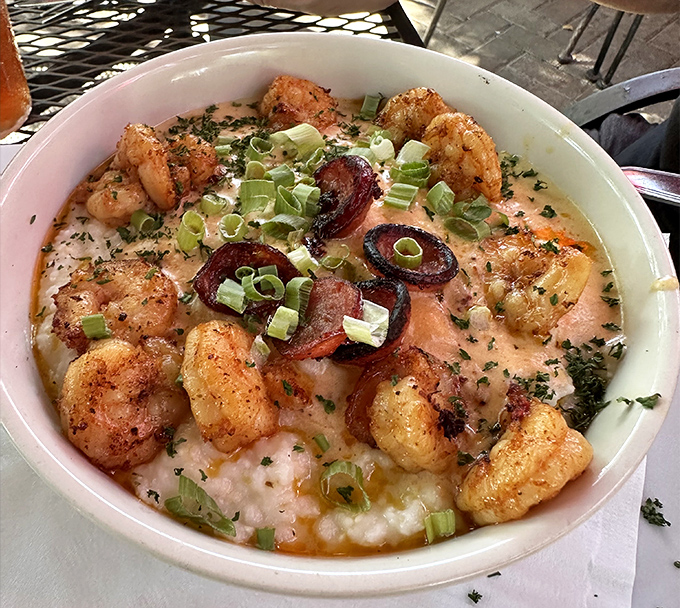The legendary shrimp and grits in their natural habitat—a bowl where plump local shrimp and creamy grits unite in perfect harmony.