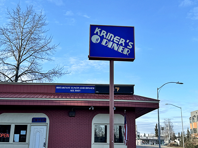 Kriner's blue sign stands tall against the Alaskan sky &ndash; a diner where breakfast meets burger perfection.
