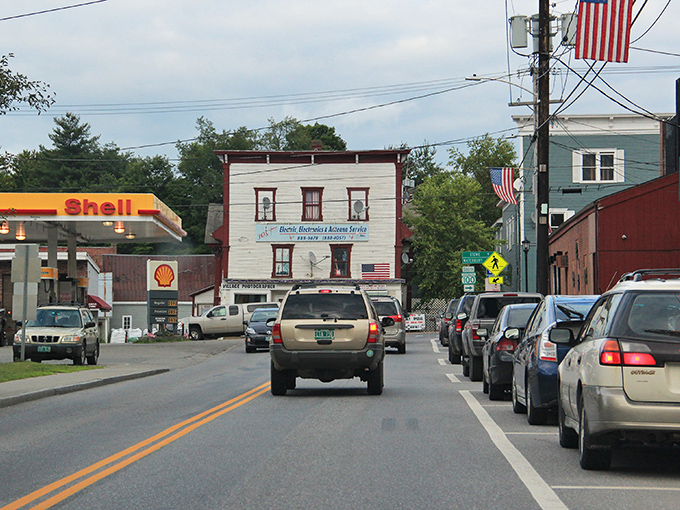 Downtown Morrisville welcomes you with classic Vermont charm. American flags flutter above the main street where cars and pedestrians share this walkable community hub.