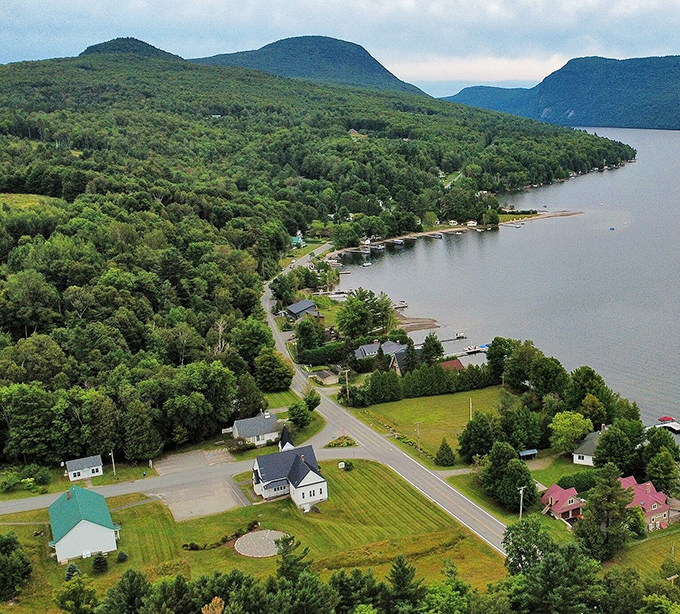 Westmore's lush green mountains embrace Lake Willoughby, creating a postcard view that wealthy tourists pay thousands to visit briefly.