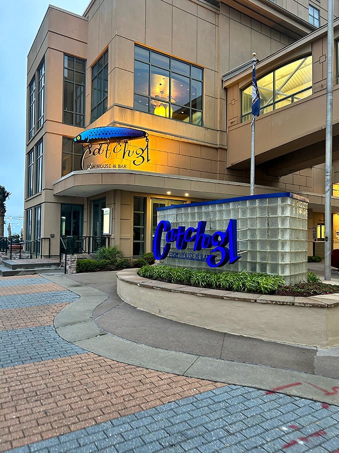 Modern seafood restaurant Catch 31 glows at dusk with its distinctive blue signage and elegant stone exterior.