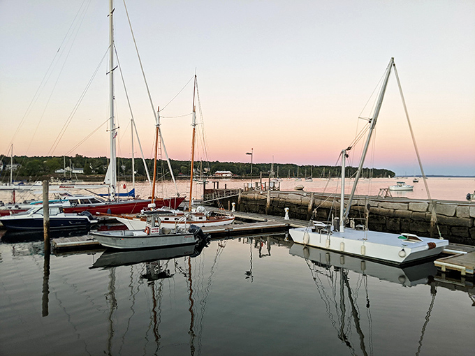 Sailboats rest in Belfast Harbor at dusk, their reflections doubling the beauty in that magical moment between day and night.