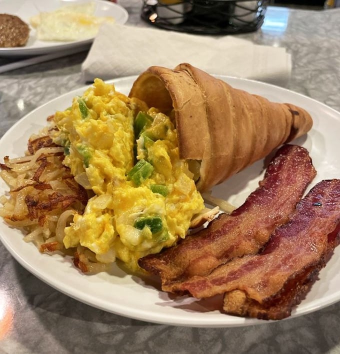 Breakfast reimagined! Scrambled eggs and veggies tucked into a cone-shaped bread vessel, with crispy hash browns standing guard. Whoever invented this deserves a Nobel Prize.