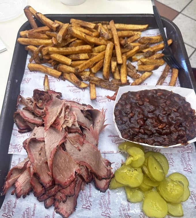 A tray of brisket, beans, and pickles &ndash; the holy trinity of Kansas City barbecue. Notice how the meat bears that perfect pink smoke ring.