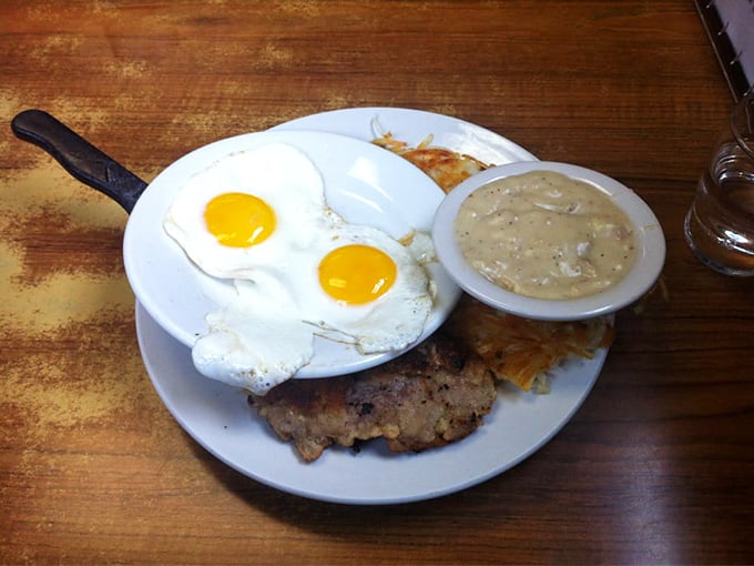Two sunny-side up eggs keeping watch over a country-fried steak with gravy standing by &ndash; breakfast architecture at its most satisfying.