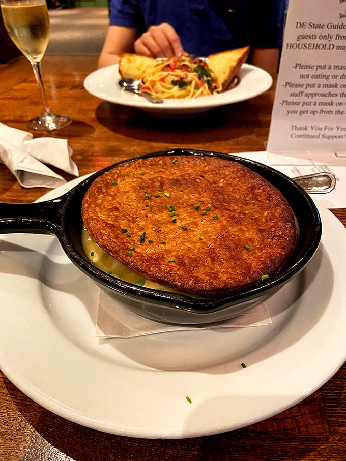 The chicken pot pie emerges bubbling in its cast iron skillet, a golden-domed monument to comfort food perfection.