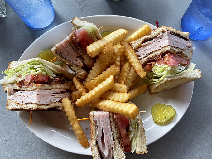 The club sandwich—architecture you can eat. Perfectly stacked, precisely cut, with those crinkle-cut fries standing at attention like delicious golden soldiers.