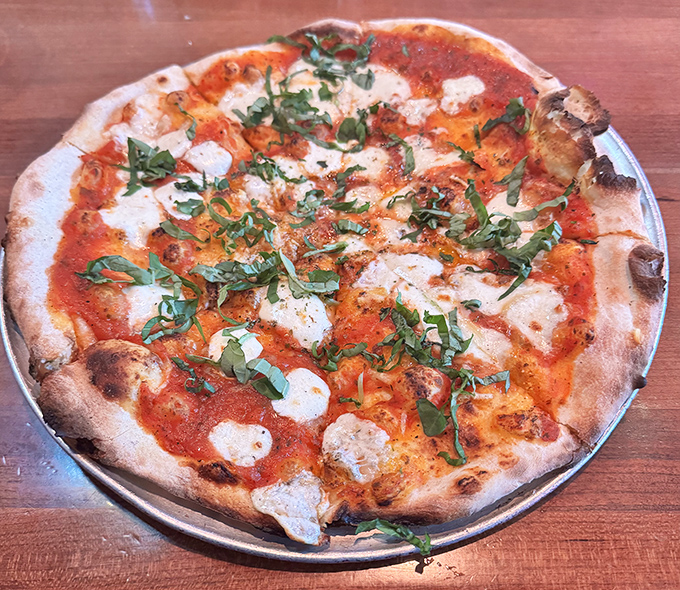 Fresh basil dancing across pools of melted mozzarella and bright tomato sauce - the Margherita pizza that launched a thousand cravings.