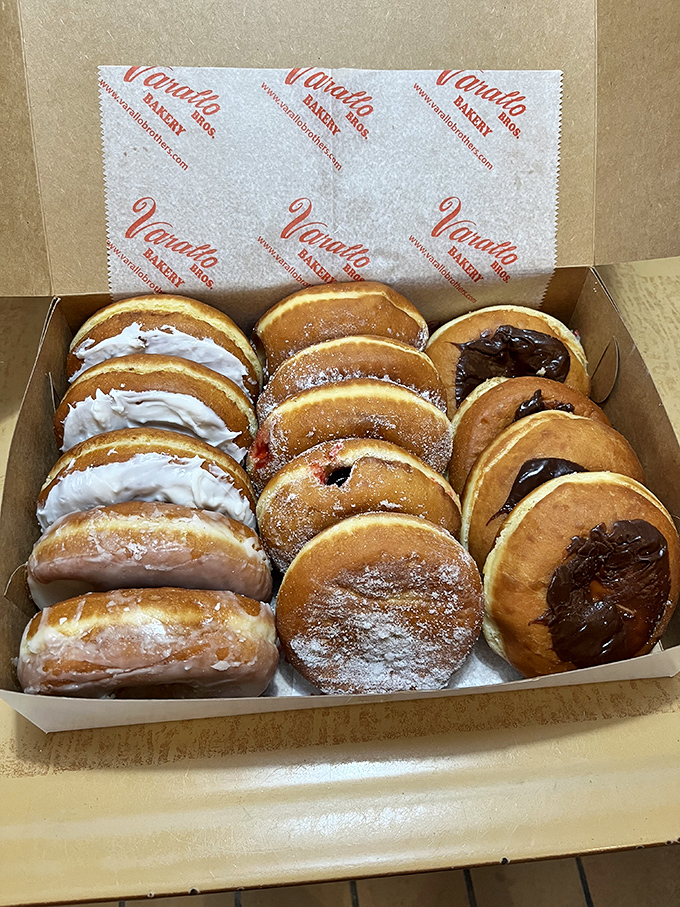 A dozen donuts lined up like sweet soldiers, each one a different temptation that makes choosing just one practically impossible.