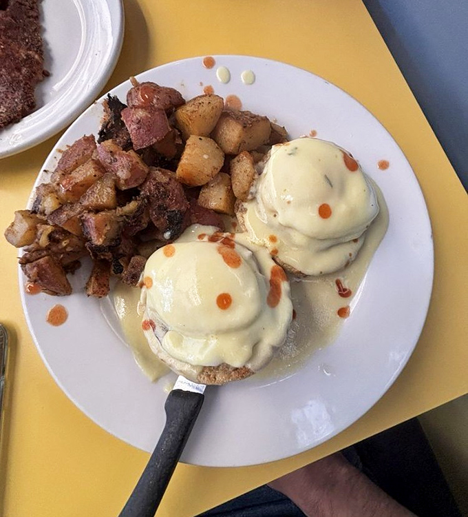 Eggs Benedict: where hollandaise meets English muffin in perfect harmony. The home fries are just showing off at this point.
