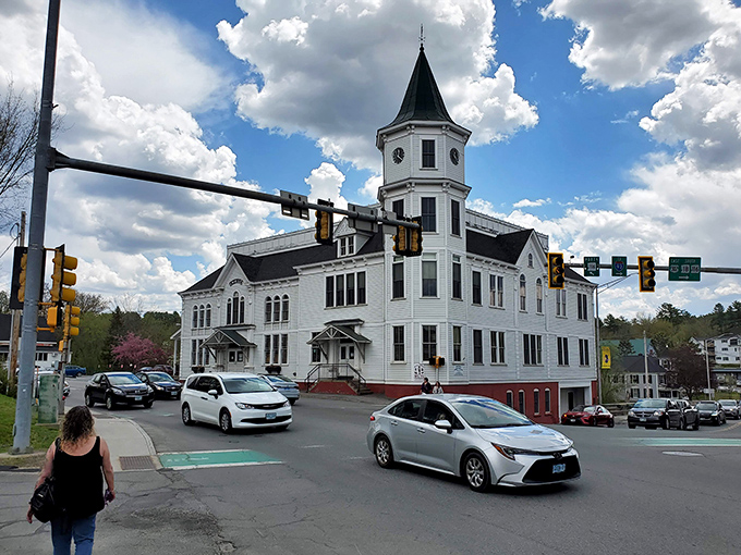 The Littleton Opera House stands proudly at the crossroads, its white tower a beacon of small-town cultural ambition.