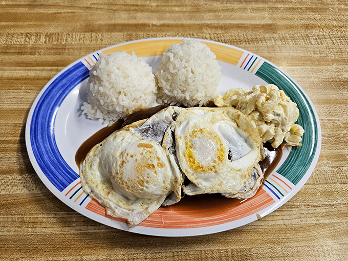 Loco Moco in its natural habitat—eggs sunny-side up, gravy cascading over a hamburger patty, all resting on a bed of rice.
